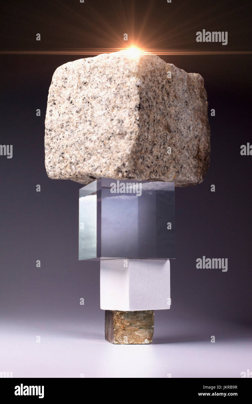 Stack of block shaped stones and glass boxes with light beam against ...