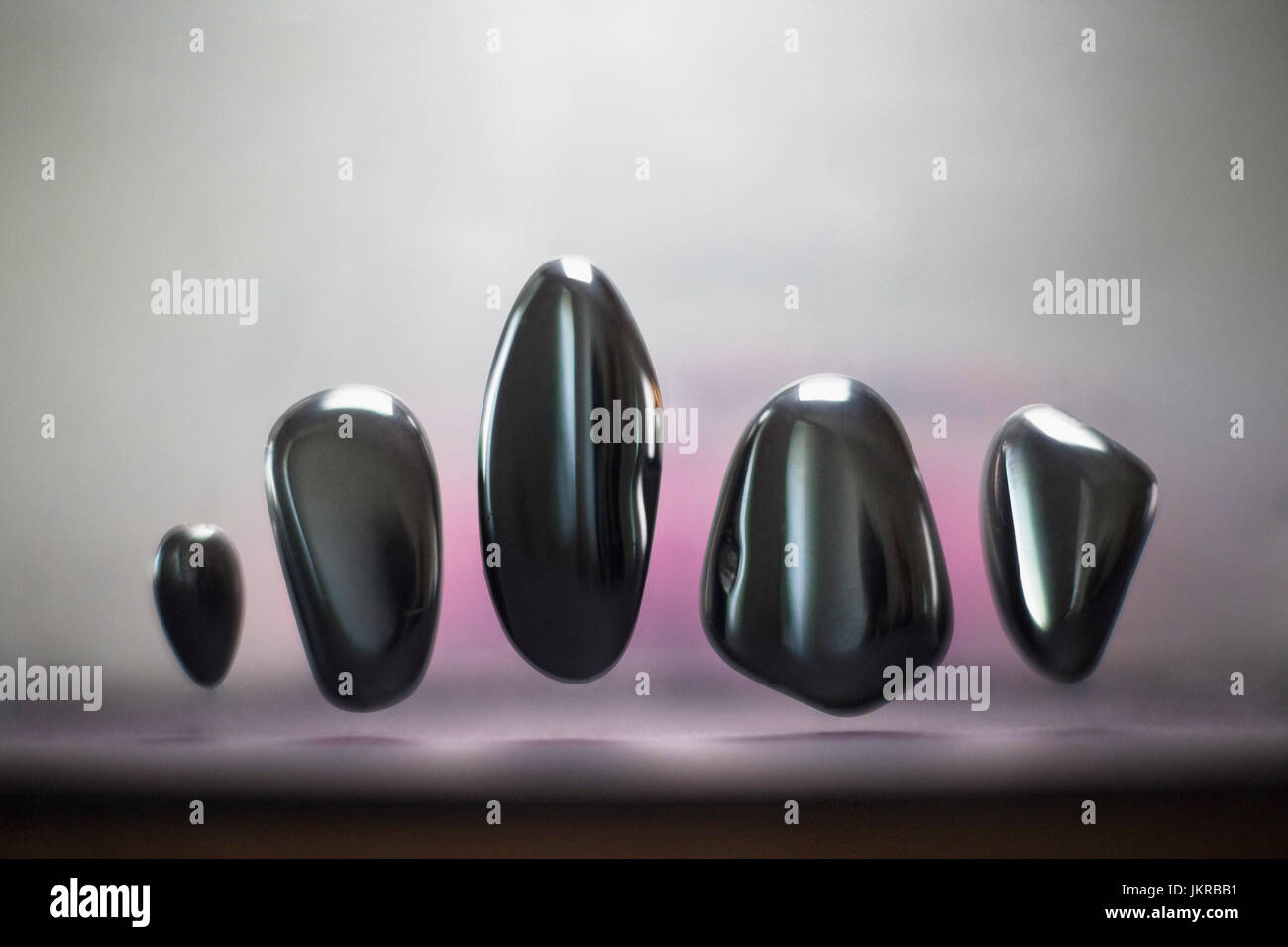 Various shape of shiny pebbles levitating against gray background Stock ...