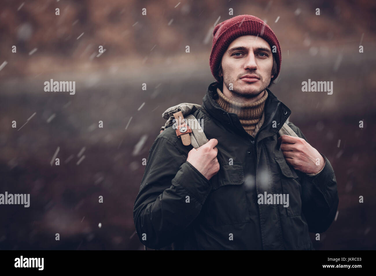 Portrait of man carrying backpack while standing outdoors during ...