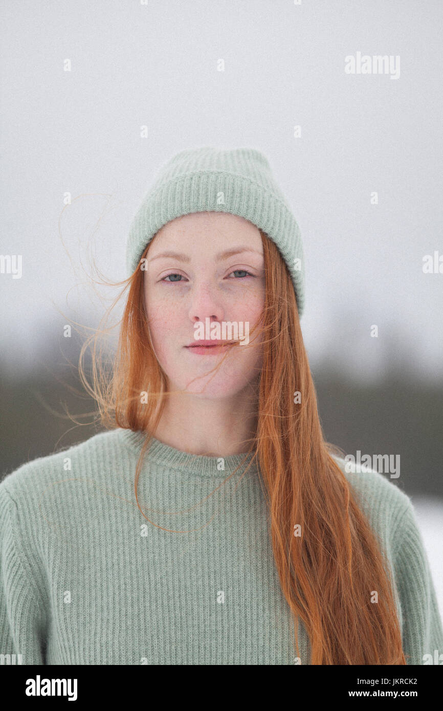 Portrait Of Confident Young Woman With Long Red Hair Wearing Knit Hat