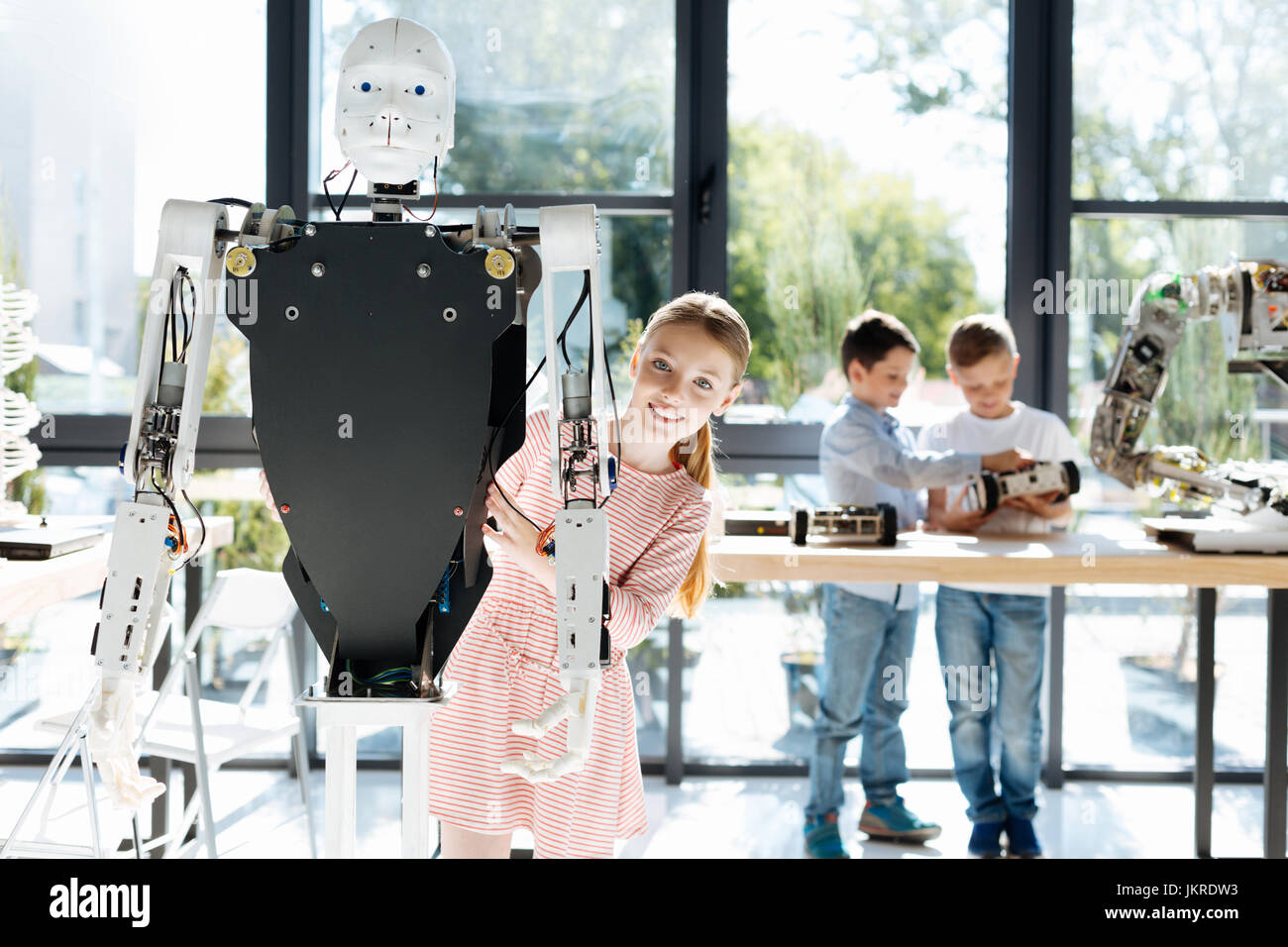 Charming girl posing behind a human robot back Stock Photo - Alamy