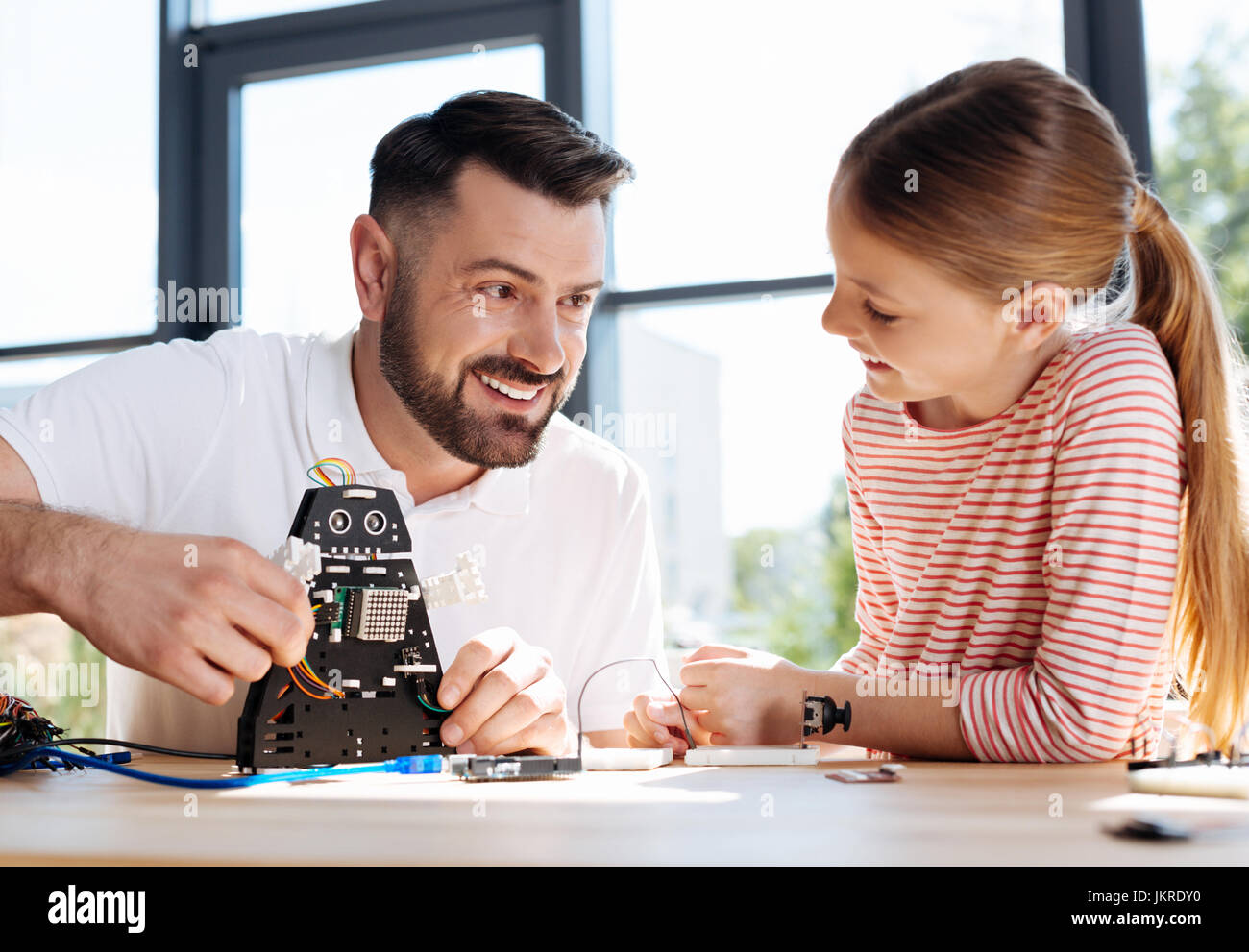Teacher waving hello to student with robots hand Stock Photo - Alamy