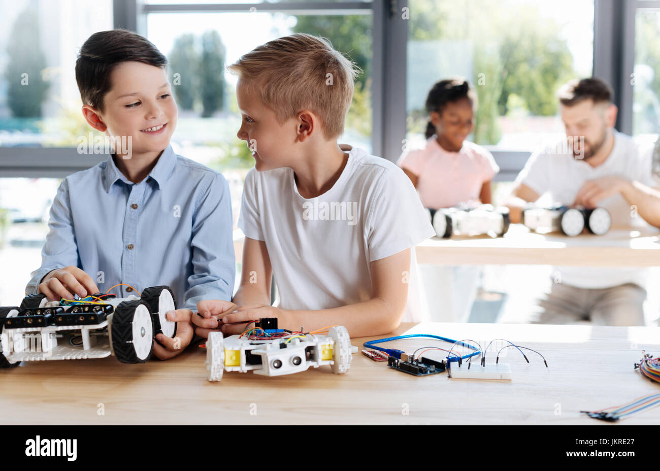 Two pre-teen students socializing during robotics class Stock Photo - Alamy