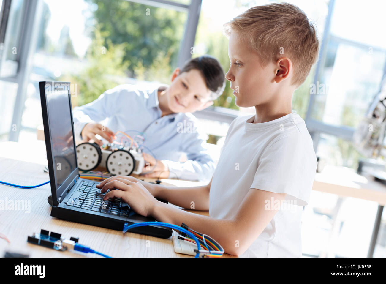 Fair-haired boy programming his new robot Stock Photo - Alamy