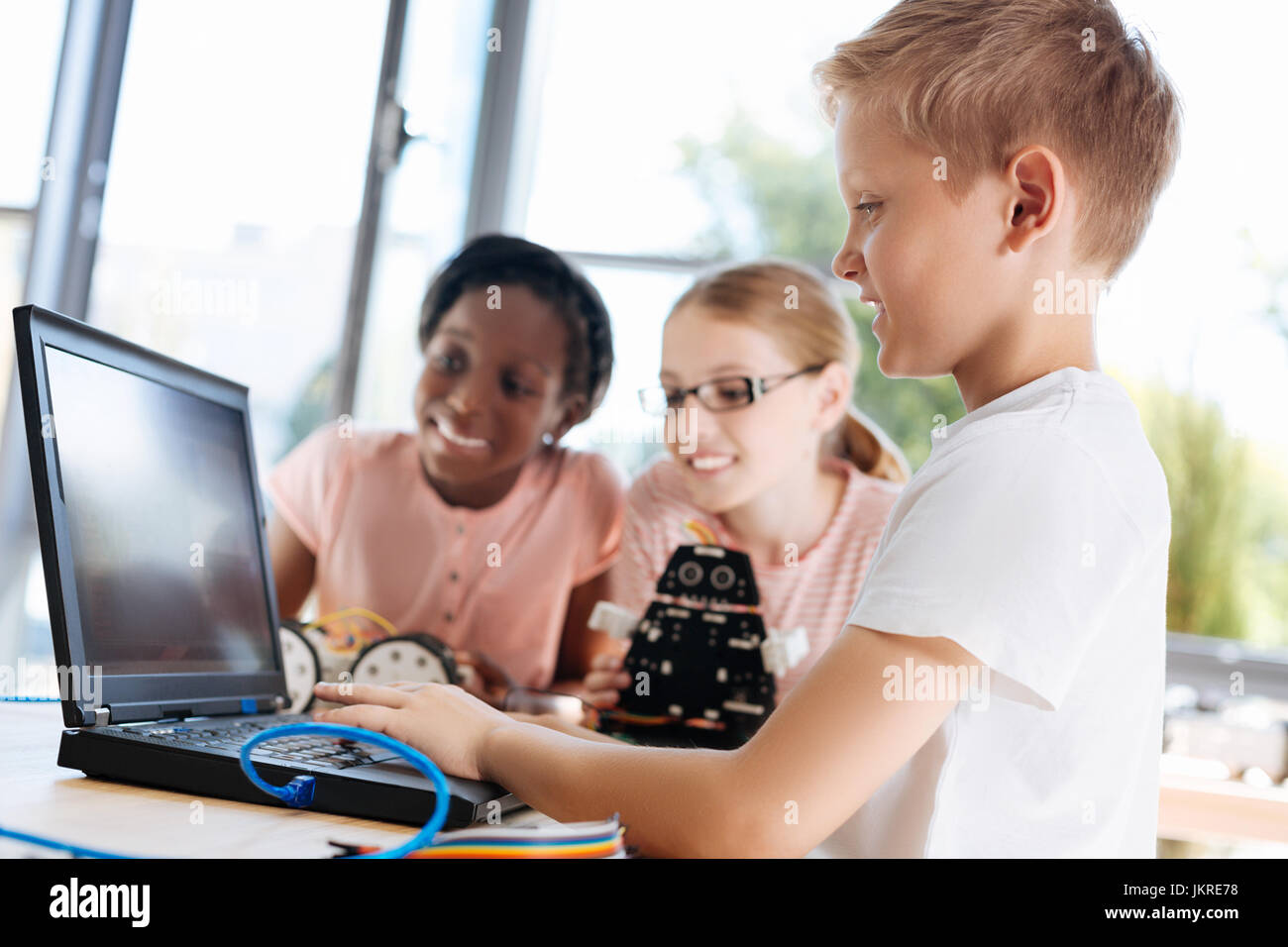 Pleasant boy watching tutorial video with his friends Stock Photo - Alamy