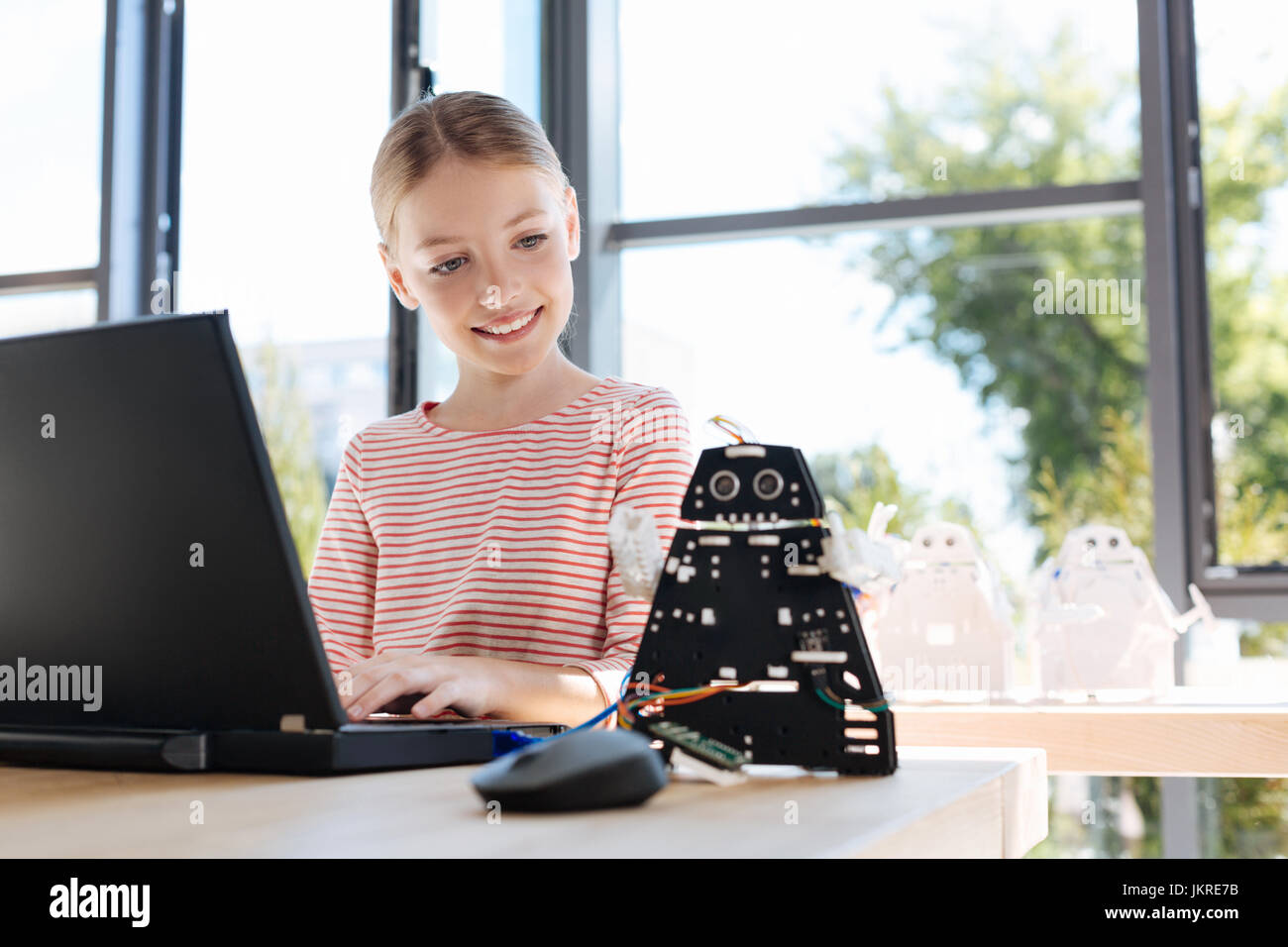 Pretty girl programming her robotic warrior Stock Photo - Alamy