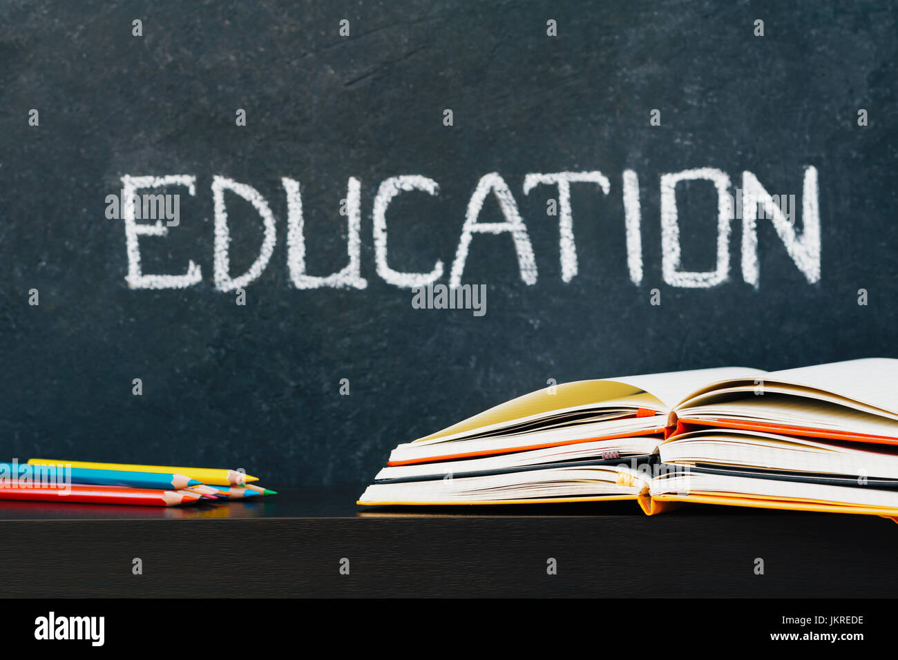 Education concept: chalk on the chalkboard, textbooks and pencils for ...