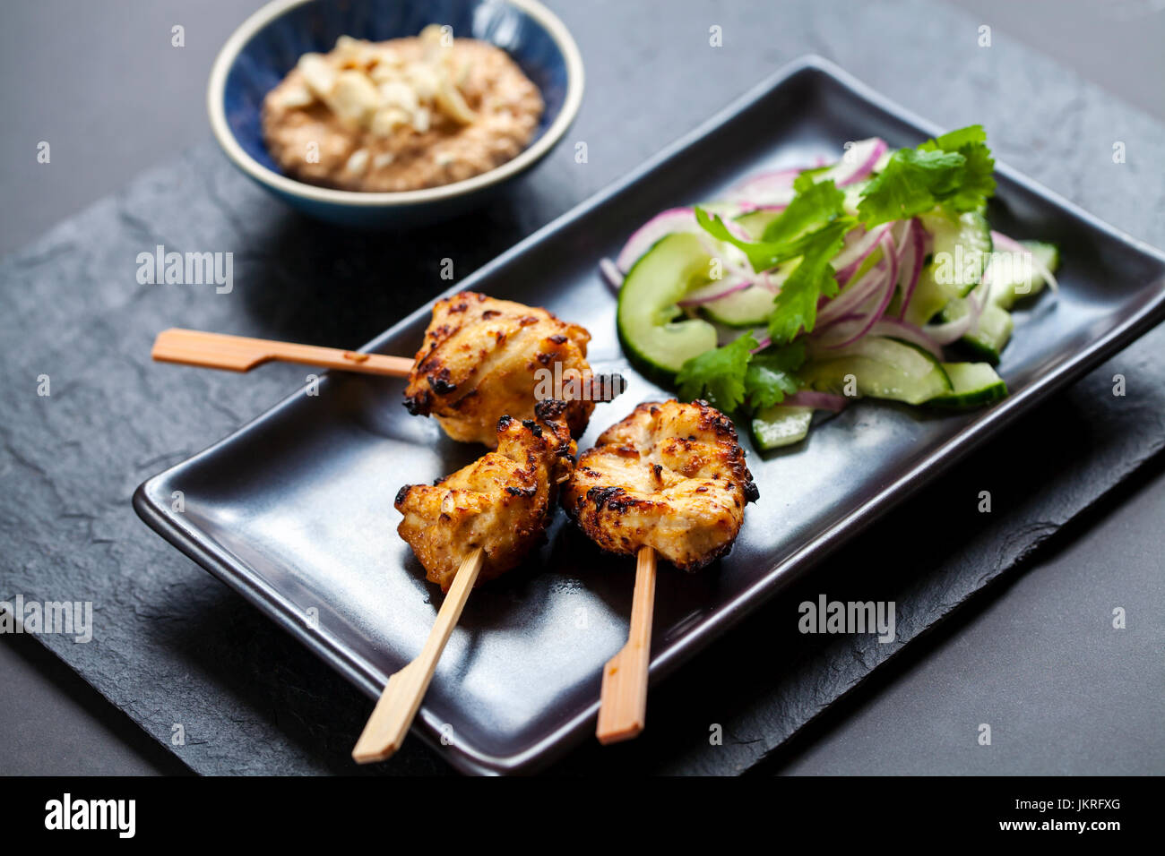 chicken satay and onion and cucumber salad Stock Photo - Alamy