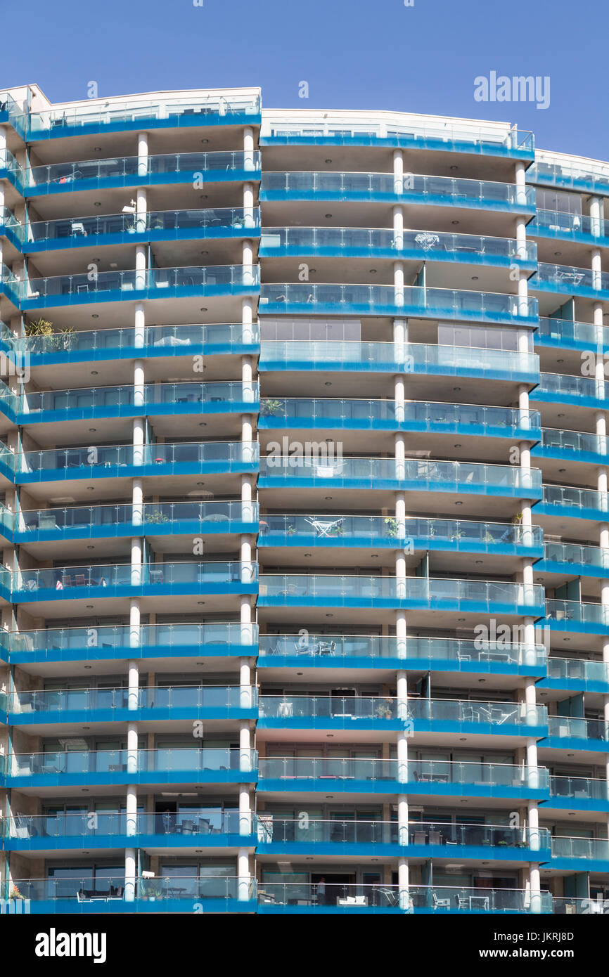 A blue glass high rise condo tower with balconies Stock Photo - Alamy