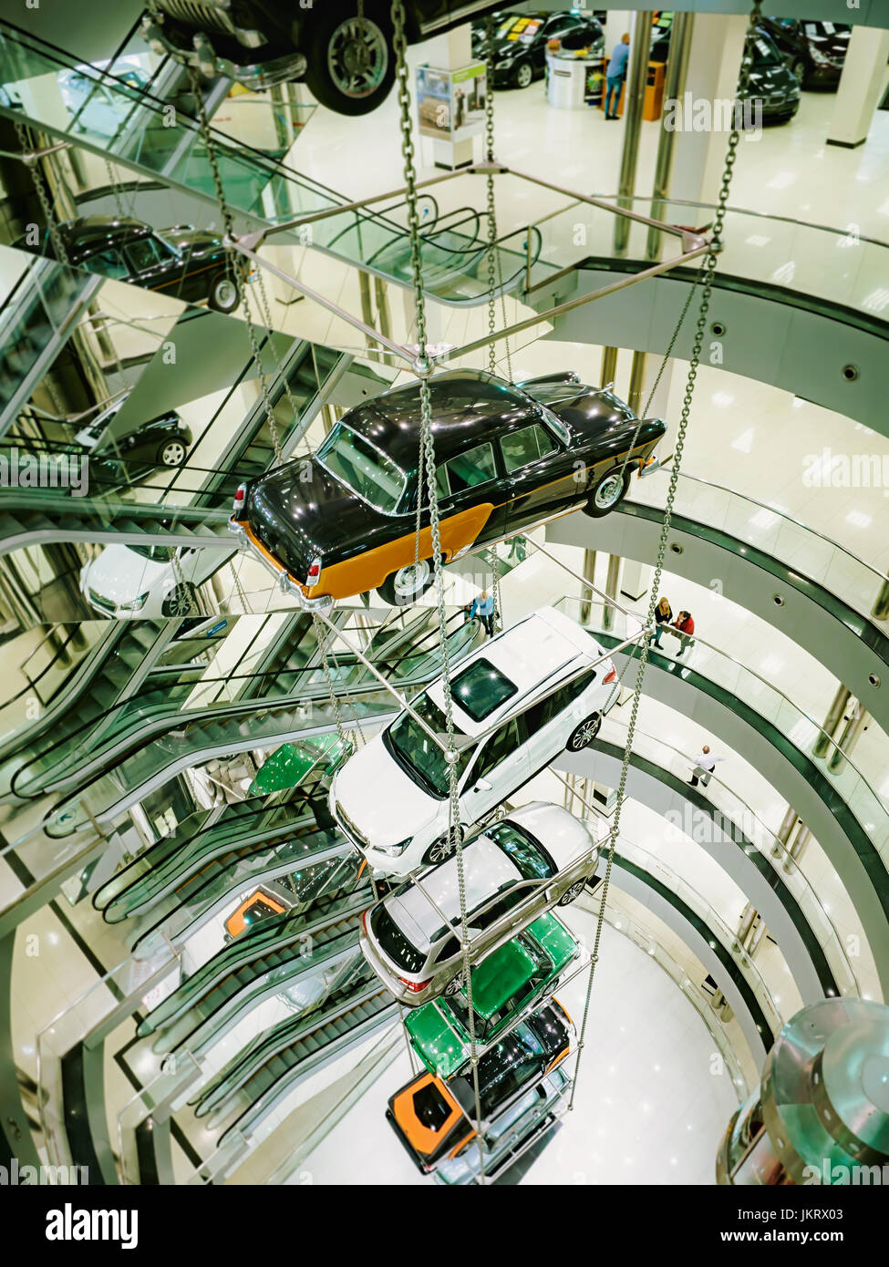 Many cars suspended on a steel cable in the car sales center. The ...