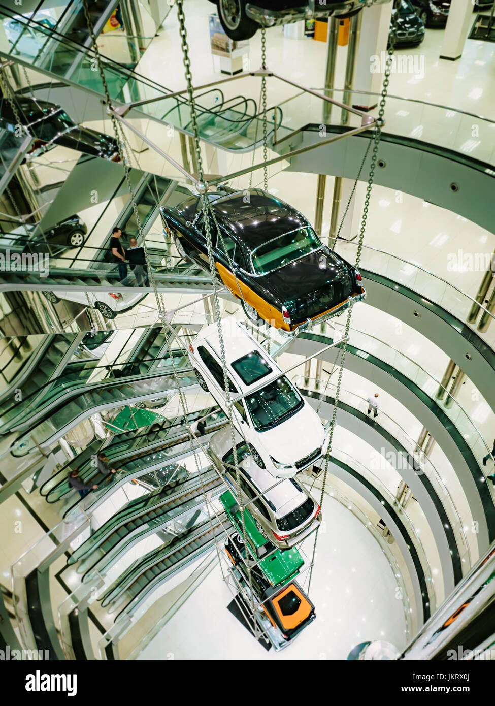 Many cars suspended on a steel cable in the car sales center. The ...