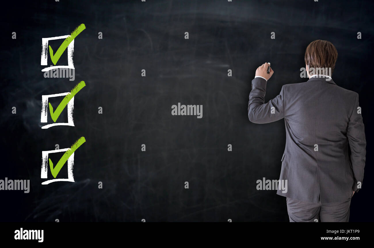 Businessman writing with checkbox concept on blackboard Stock Photo - Alamy