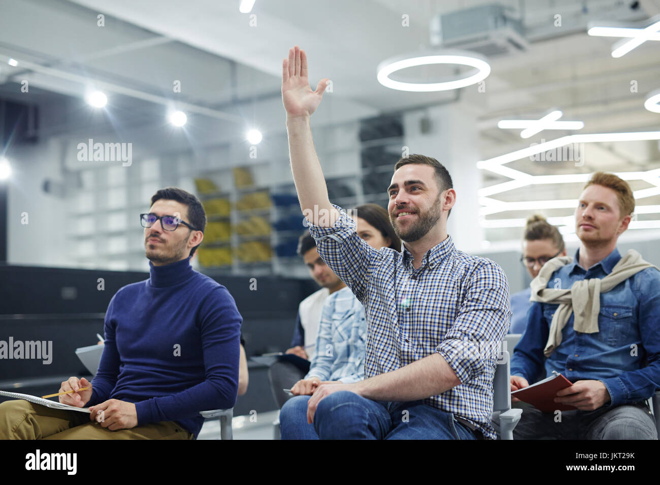 One of students raising hand to answer Stock Photo - Alamy