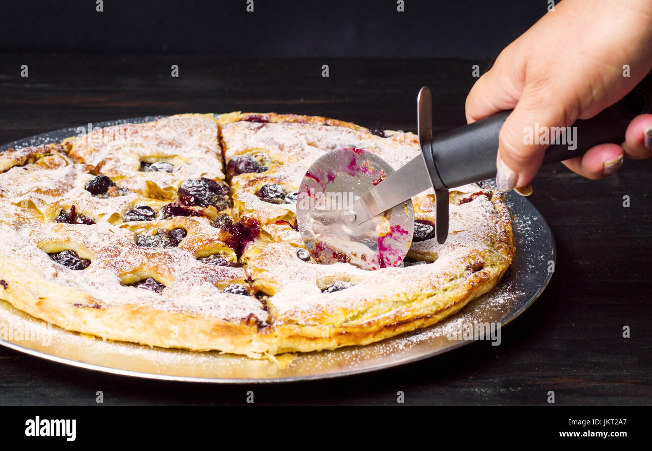 Female cutting sweet pie with a roller cutter knife Stock Photo - Alamy