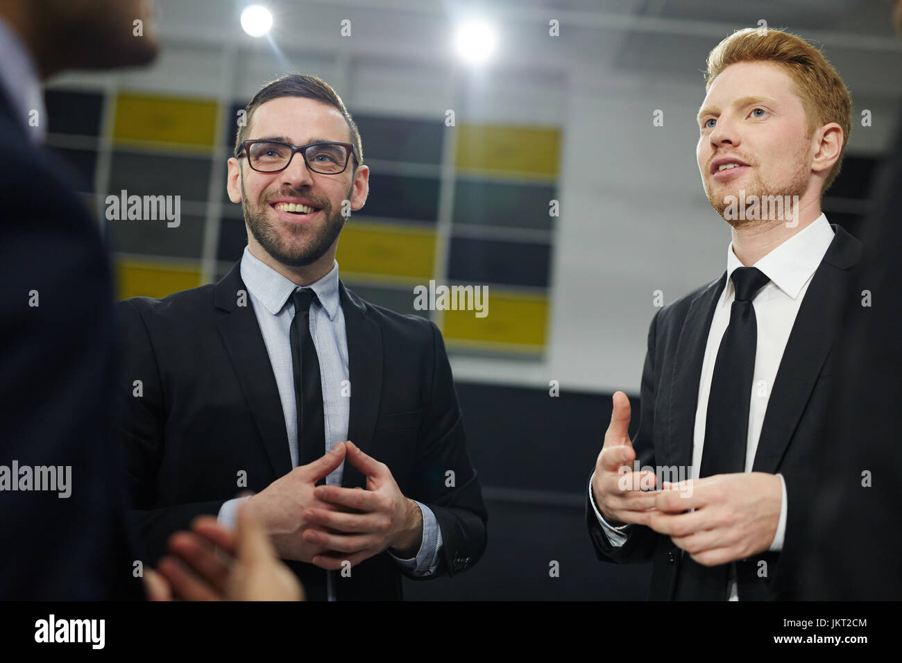 Elegant professionals talking to business partner Stock Photo - Alamy