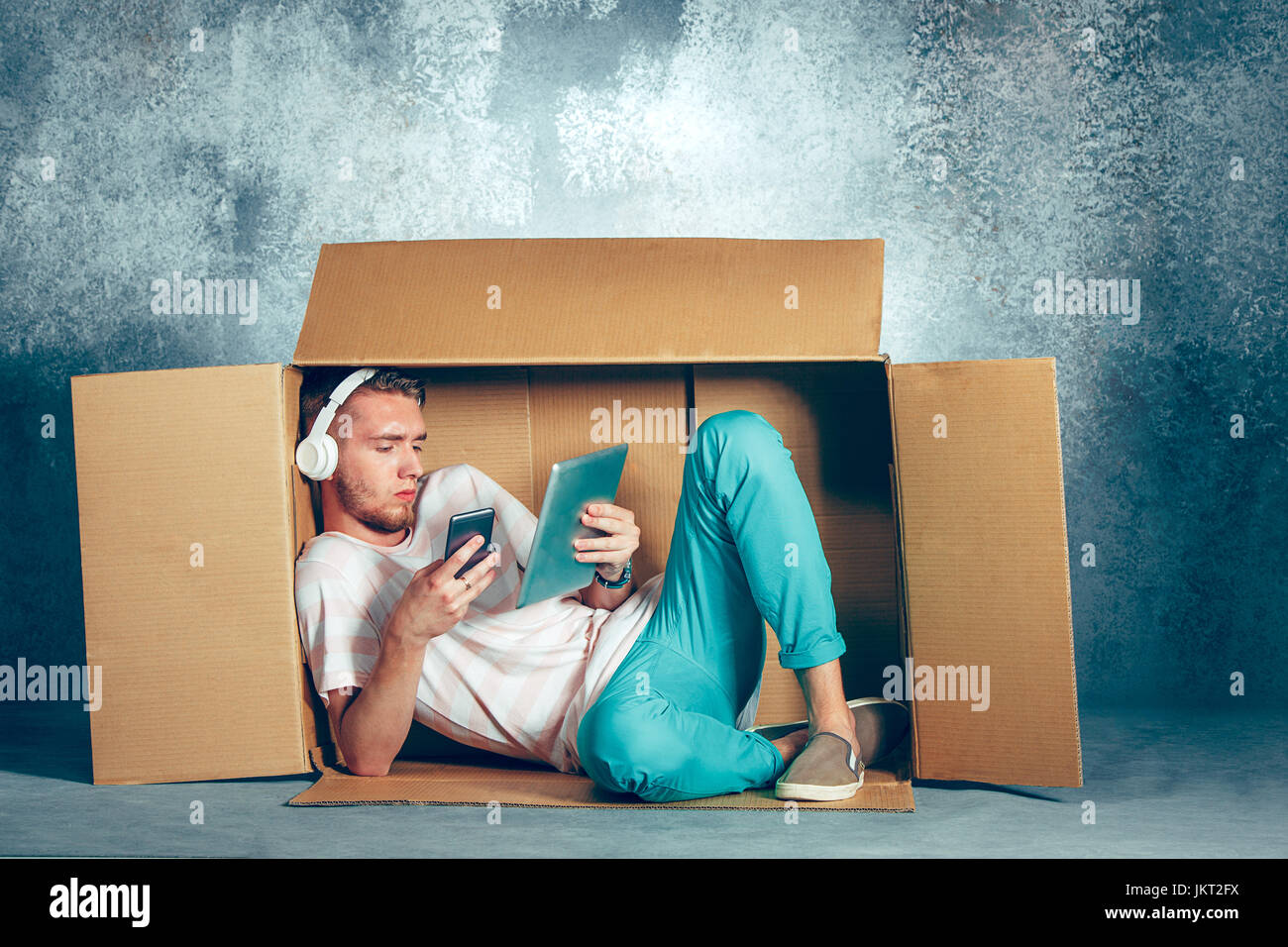 Introvert concept. Man sitting inside box and working with phone Stock ...