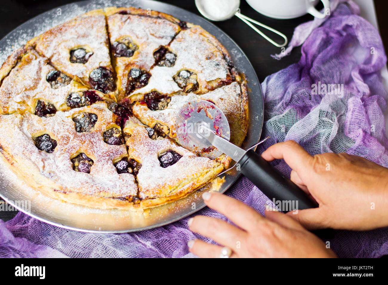 Female hand cutting sweet pie with a roller cutter Stock Photo - Alamy