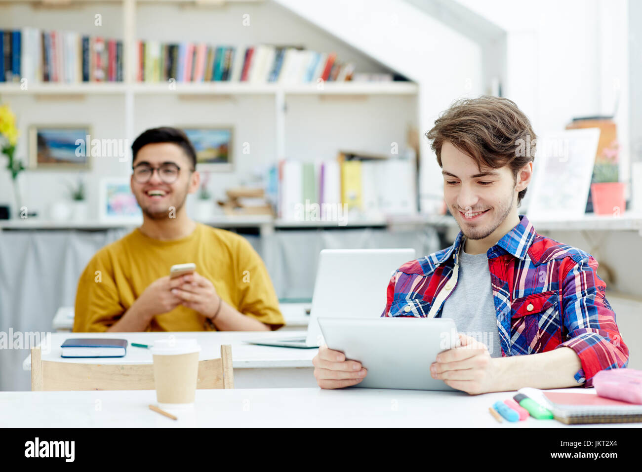 Mobile student with tablet talking through video chat in classroom ...