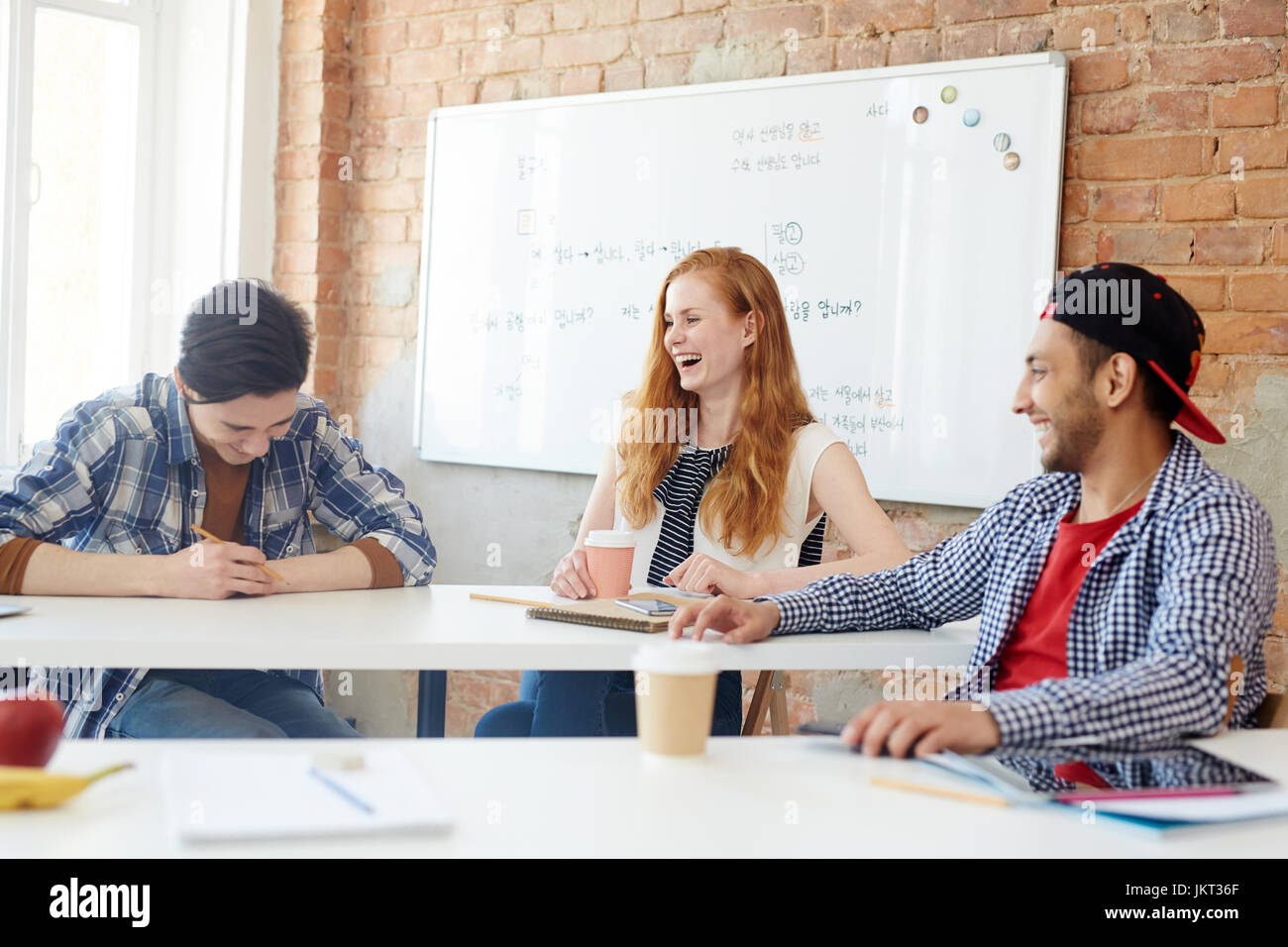 Group of laughing groupmates having talk in classroom Stock Photo - Alamy