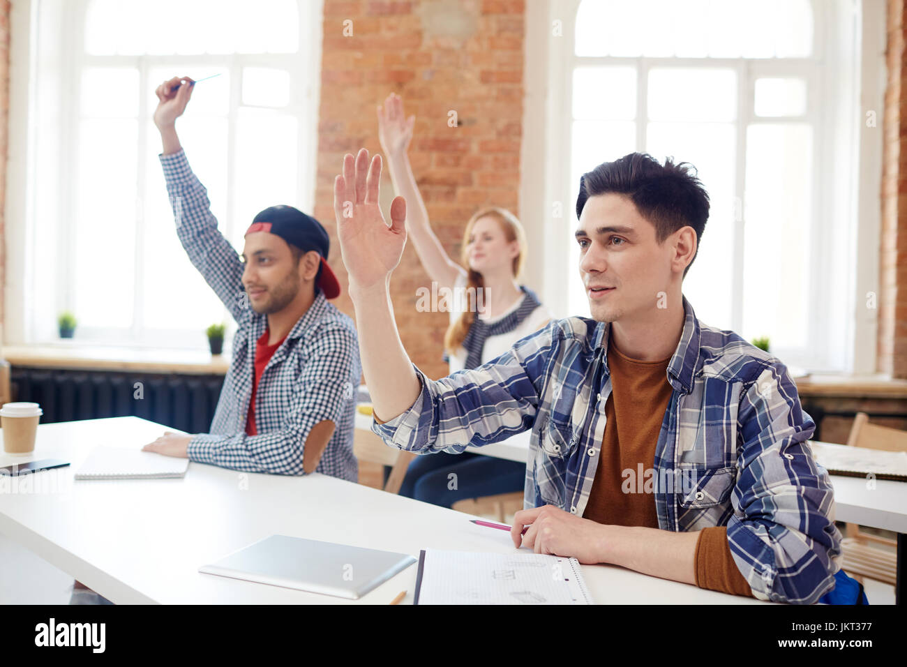 Clever teens raising hands at lesson Stock Photo - Alamy Clever teens raising hands at lesson Stock Photo - Alamy