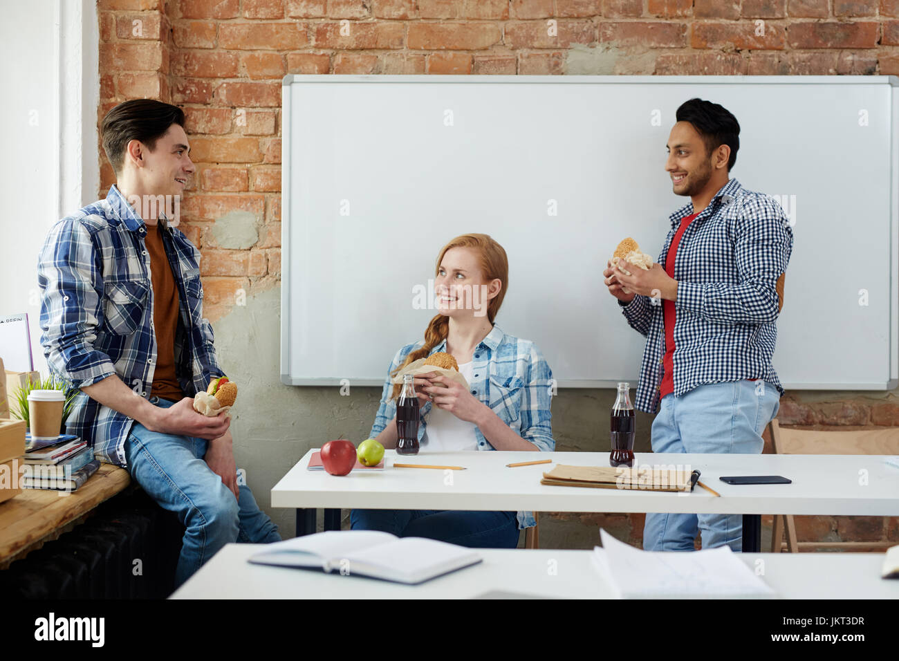 Friendly groupmates having talk by lunch in classroom Stock Photo - Alamy