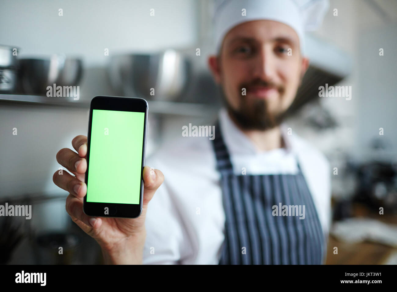 Chef showing new online recipe in smartphone Stock Photo - Alamy