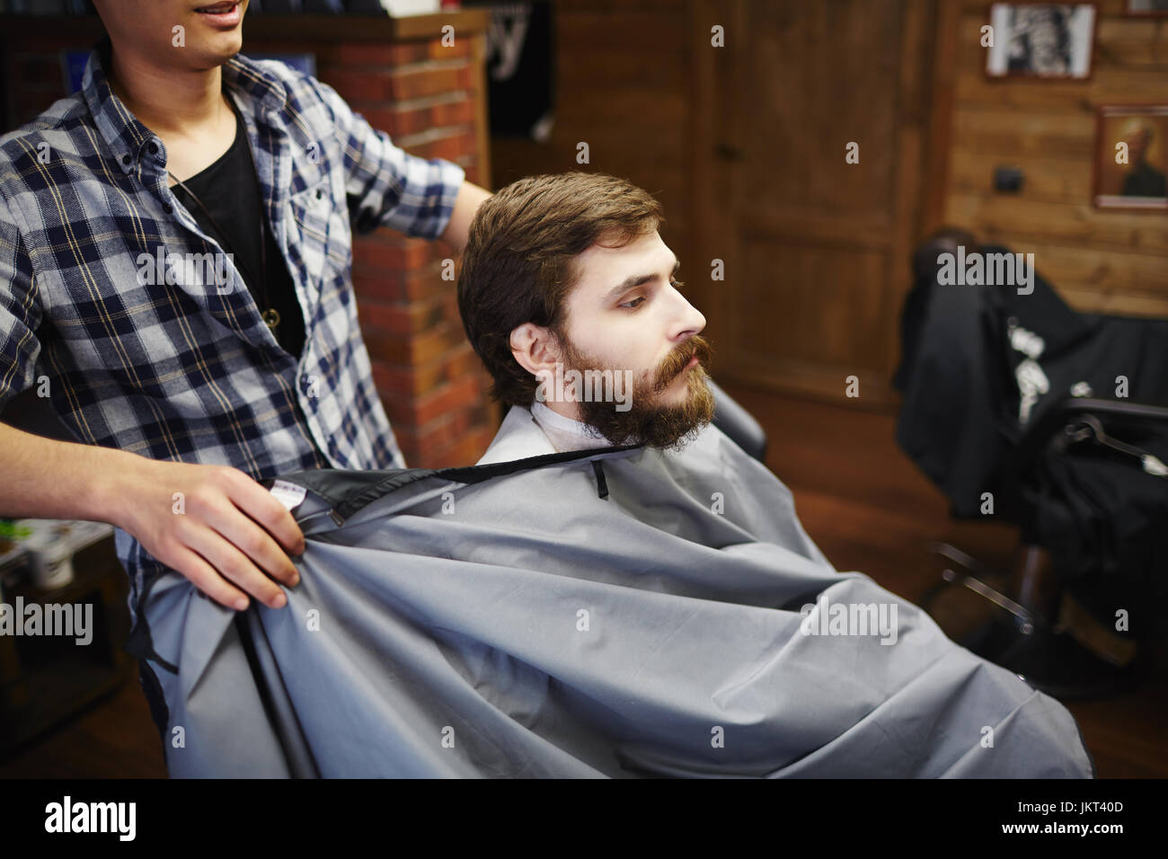 Hairdresser preparing client for haircutting Stock Photo - Alamy