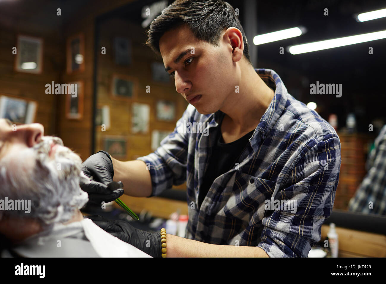 Professional barber shaving his client beard Stock Photo - Alamy