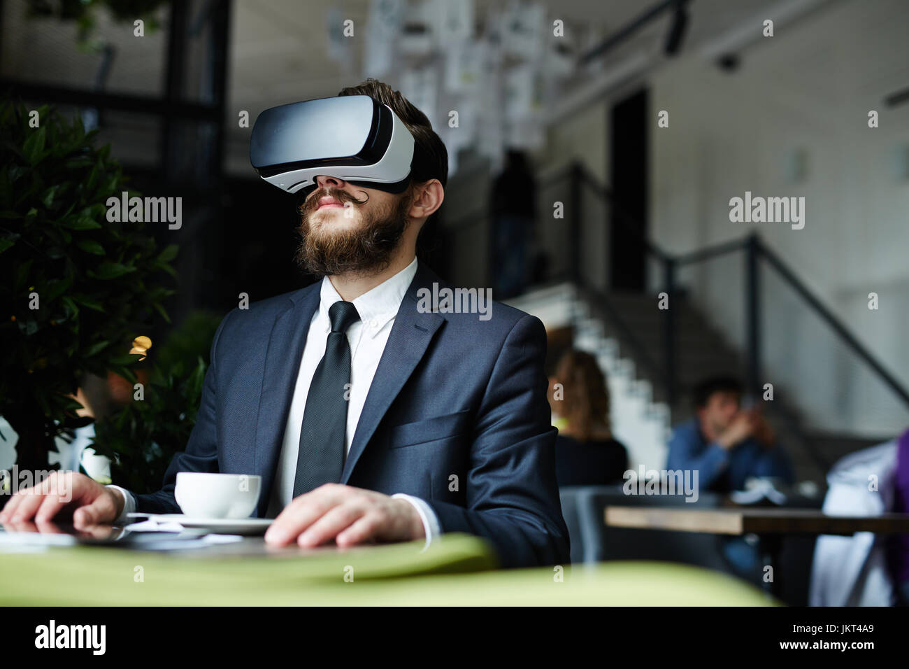 Businessman having virtual experience in cafe Stock Photo - Alamy