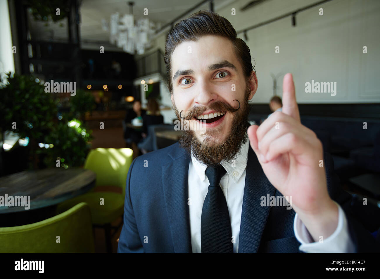 Inspired businessman pointing forefinger up Stock Photo - Alamy