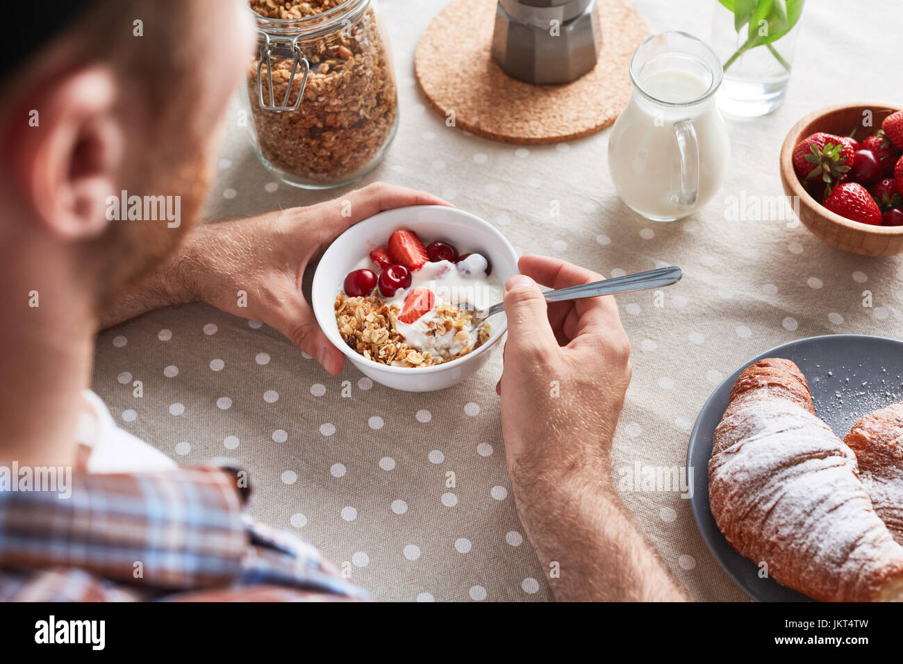 Man eating muesli with yogurt and fresh berries by breakfast Stock ...