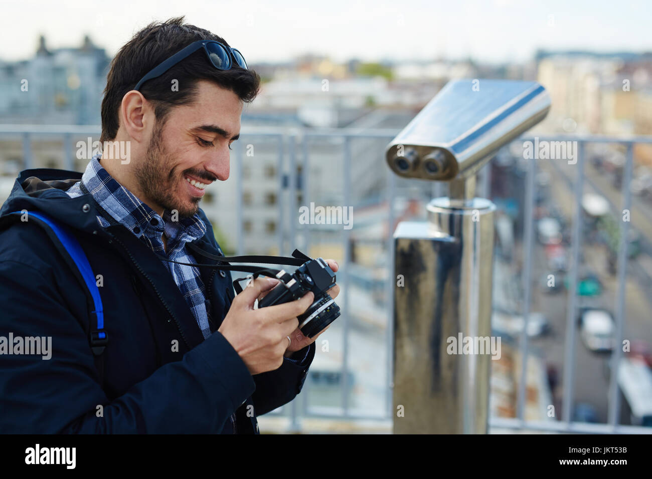 Side view portrait of modern solo tourist using photo camera to browse ...
