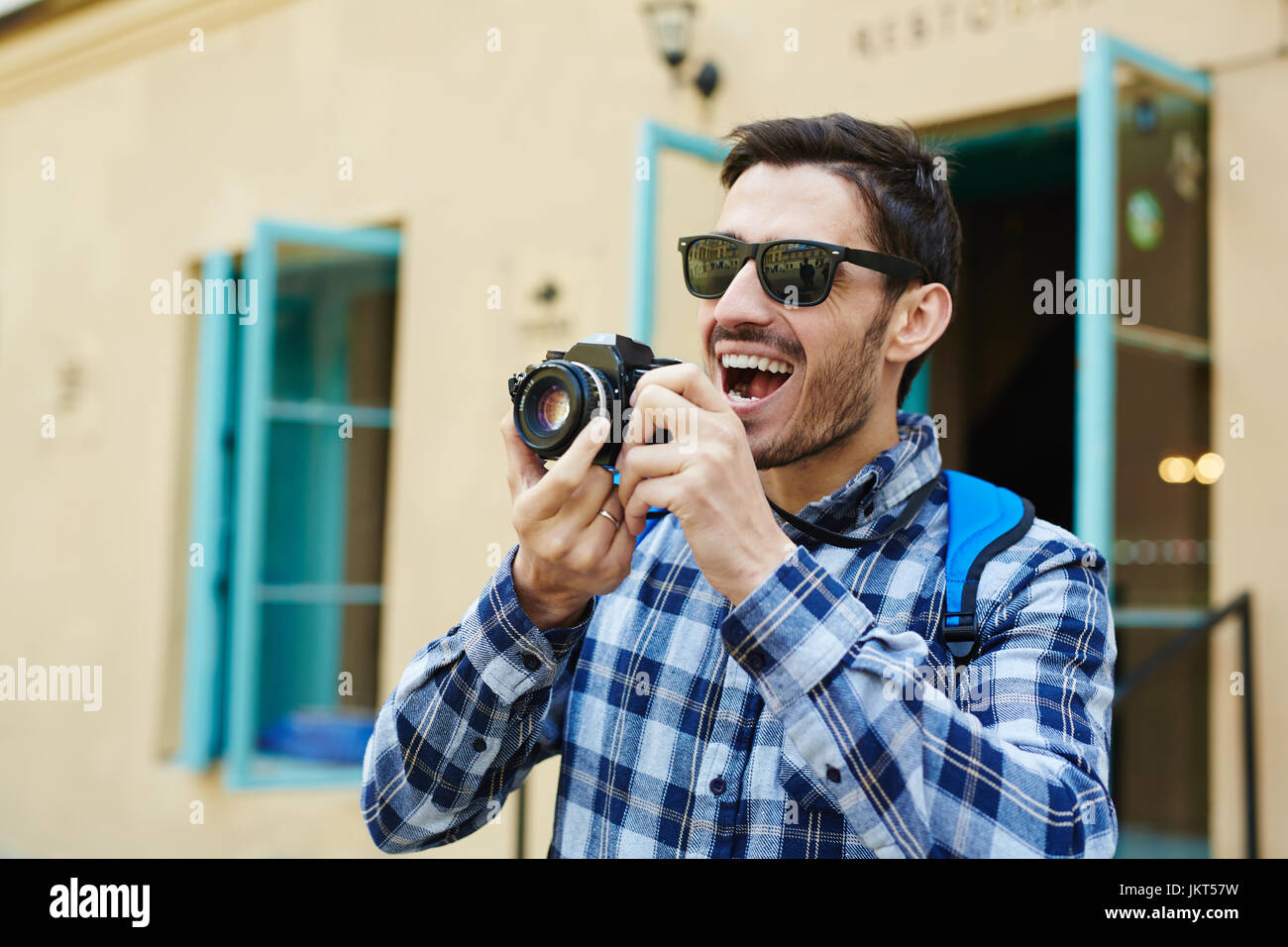 Portrait of handsome young man taking photos in streets of old city ...