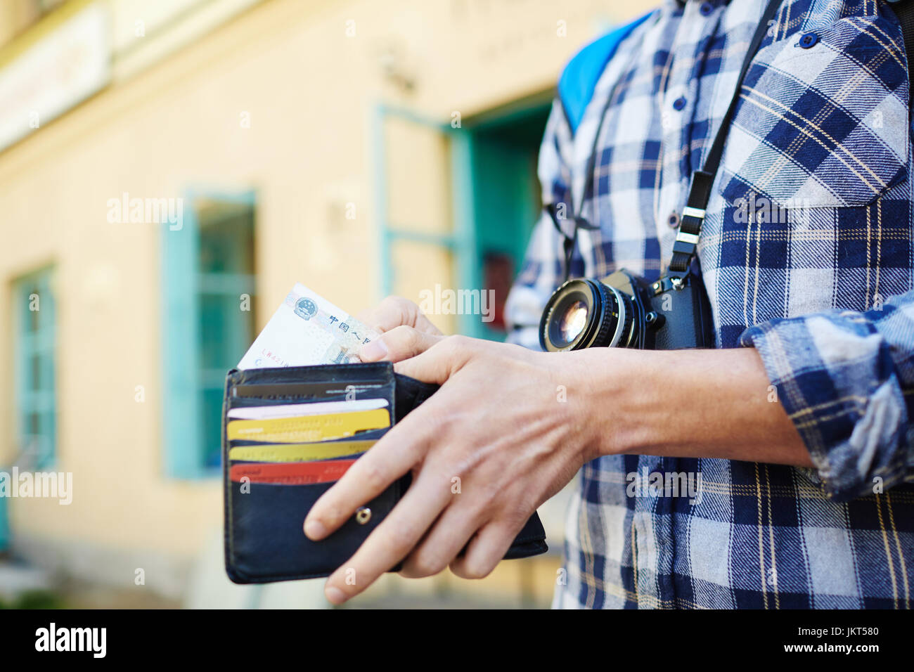 Closeup image of young tourist putting money in wallet, saving money ...