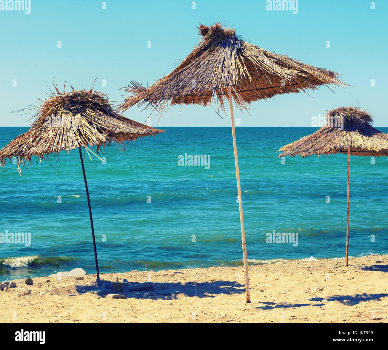 Straw beach umbrellas. Sunny day on the beach. Straw parasols ...