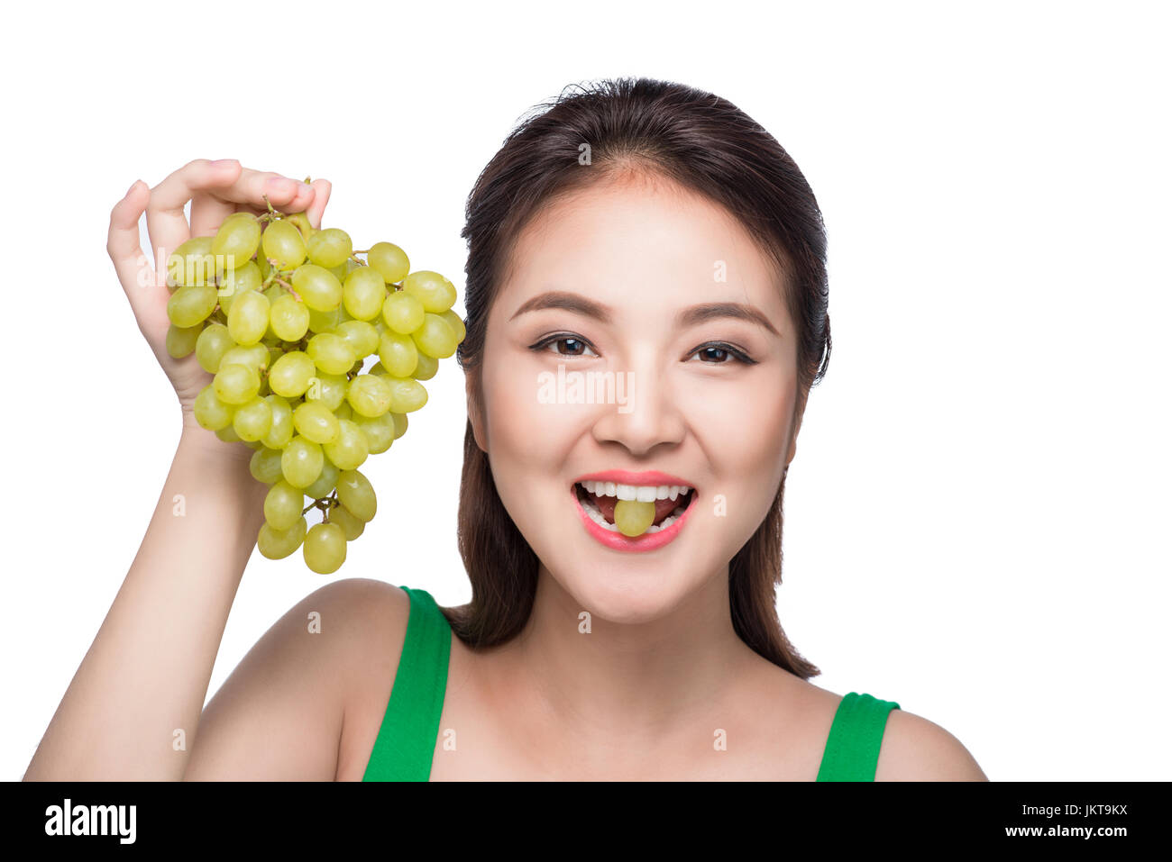 Young beautiful asian woman eating fresh grapes isolated on white ...