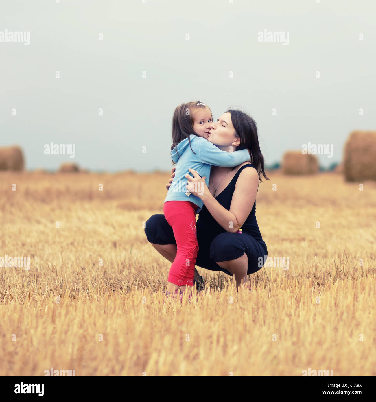 Photo of mother and her daughter child girl hugging in the field on ...