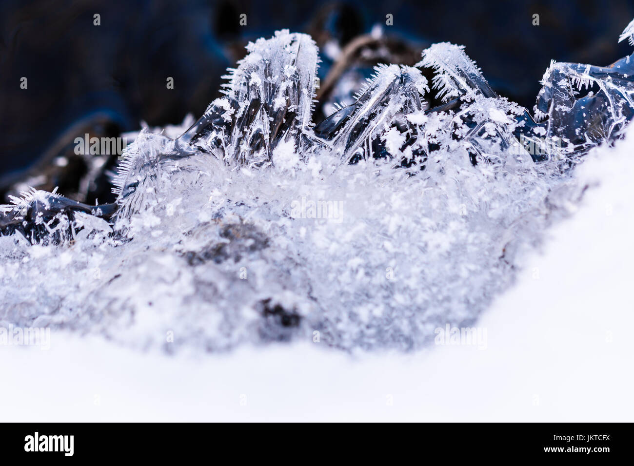 Macro view of small ice in river in winter. On border is snow ...