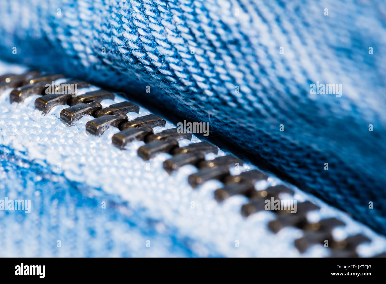 A closeup view of fastener of light blue jeans. Good visible texture ...