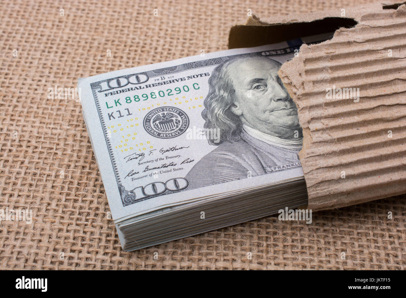 Banknote bundle of US dollar partly wrapped in cardboard Stock Photo ...