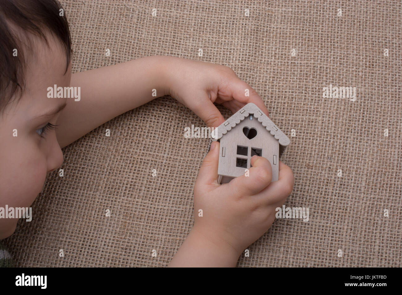 Child holding a model house on a linen canvas Stock Photo - Alamy