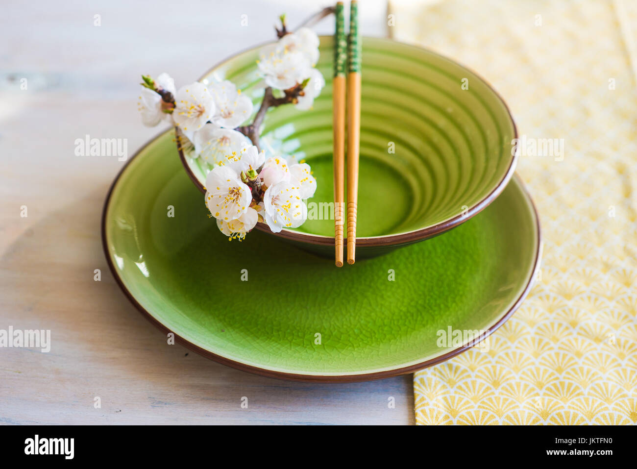 Spring table setting with chopsticks and peach blooming on a wooden ...