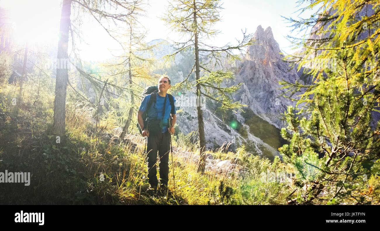 Hiker man smiles in morning sunrise. Forest and mountains Stock Photo ...