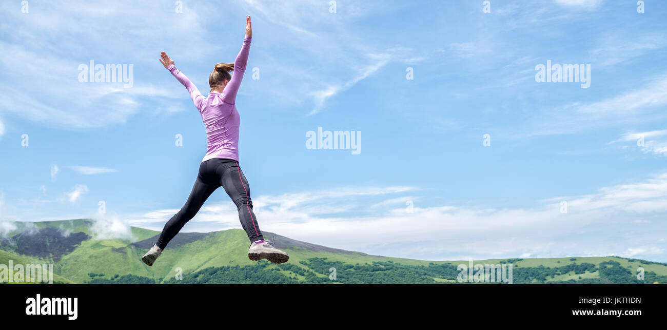 Young woman jumping in the mountains Stock Photo - Alamy