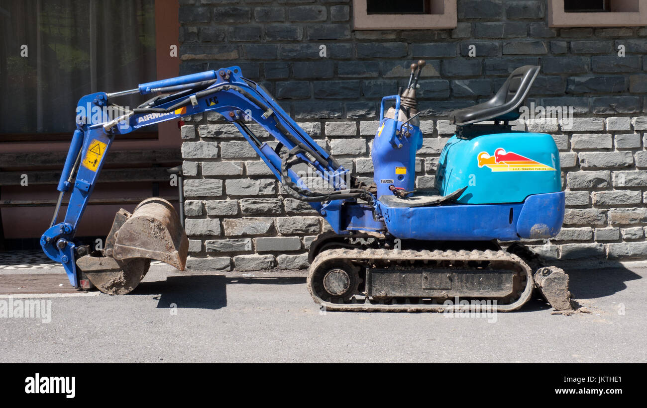 Small earthmover outside house, Alps Stock Photo - Alamy