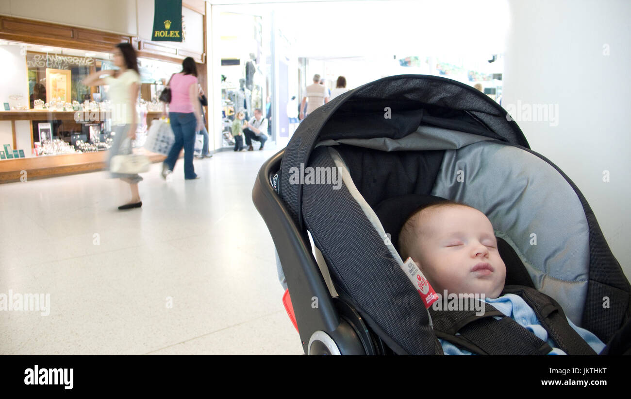 Baby in stroller in shopping centre Stock Photo - Alamy