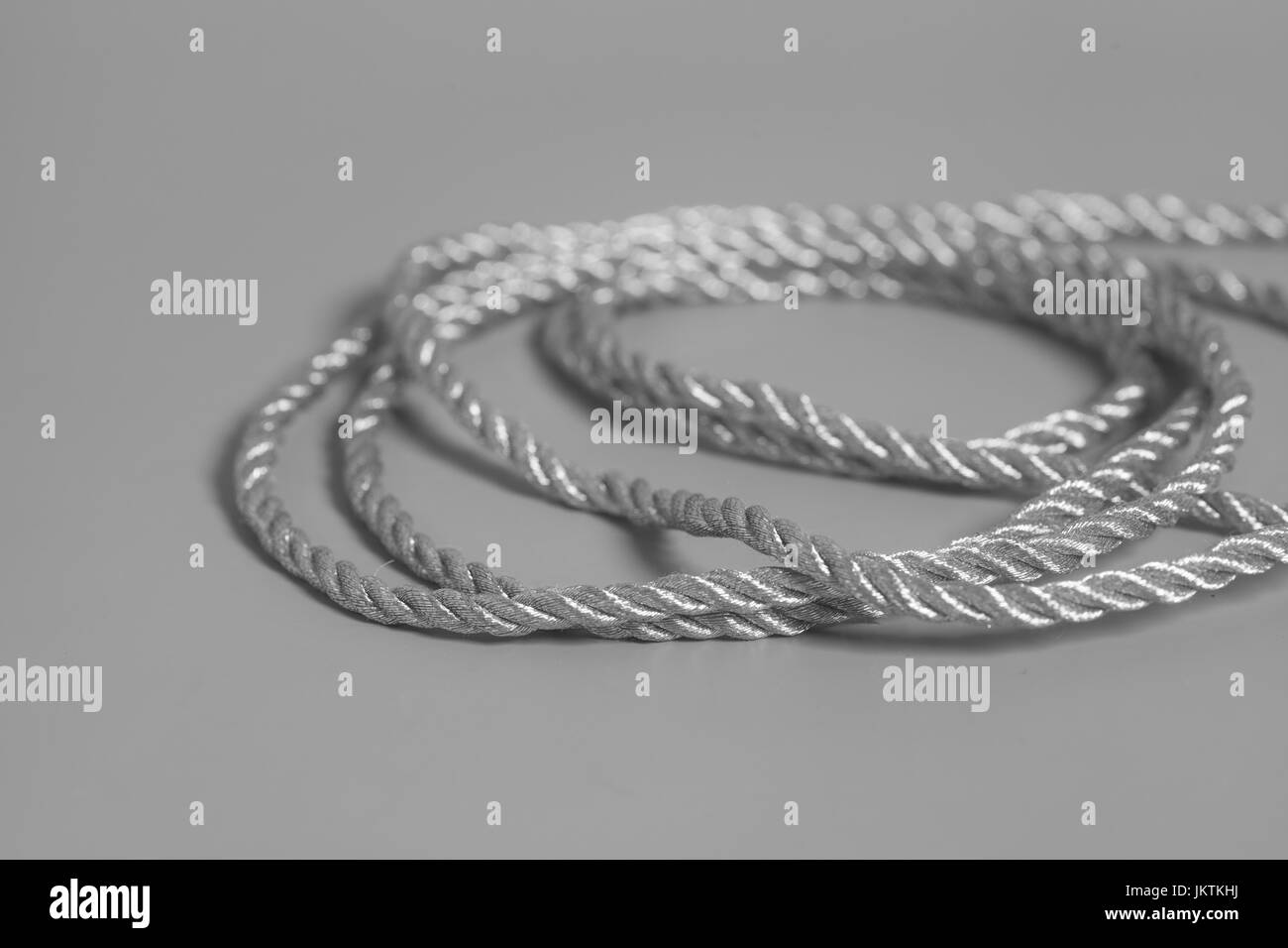 Silver rope on gray background Stock Photo - Alamy