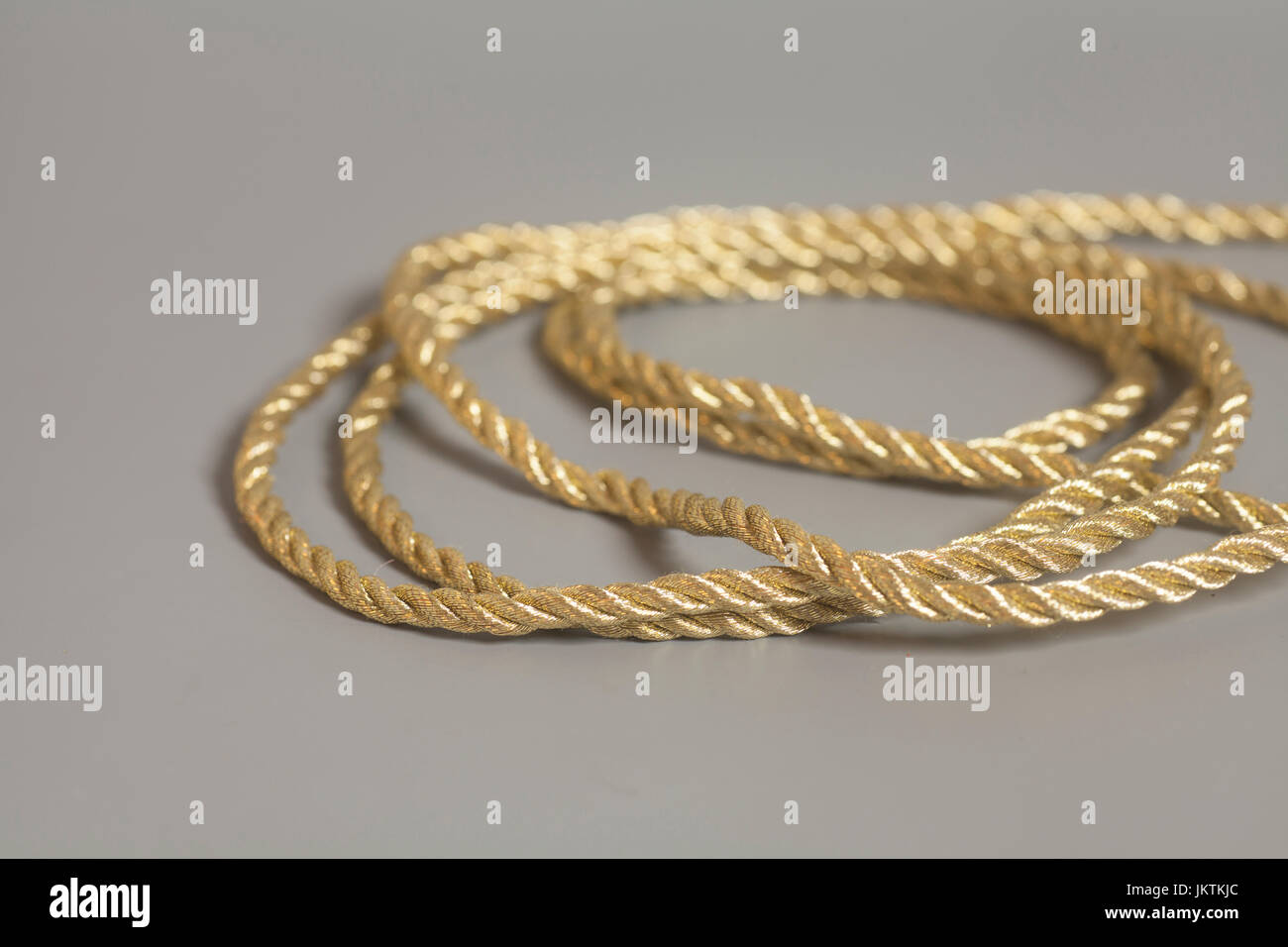 Golden rope on gray background Stock Photo - Alamy
