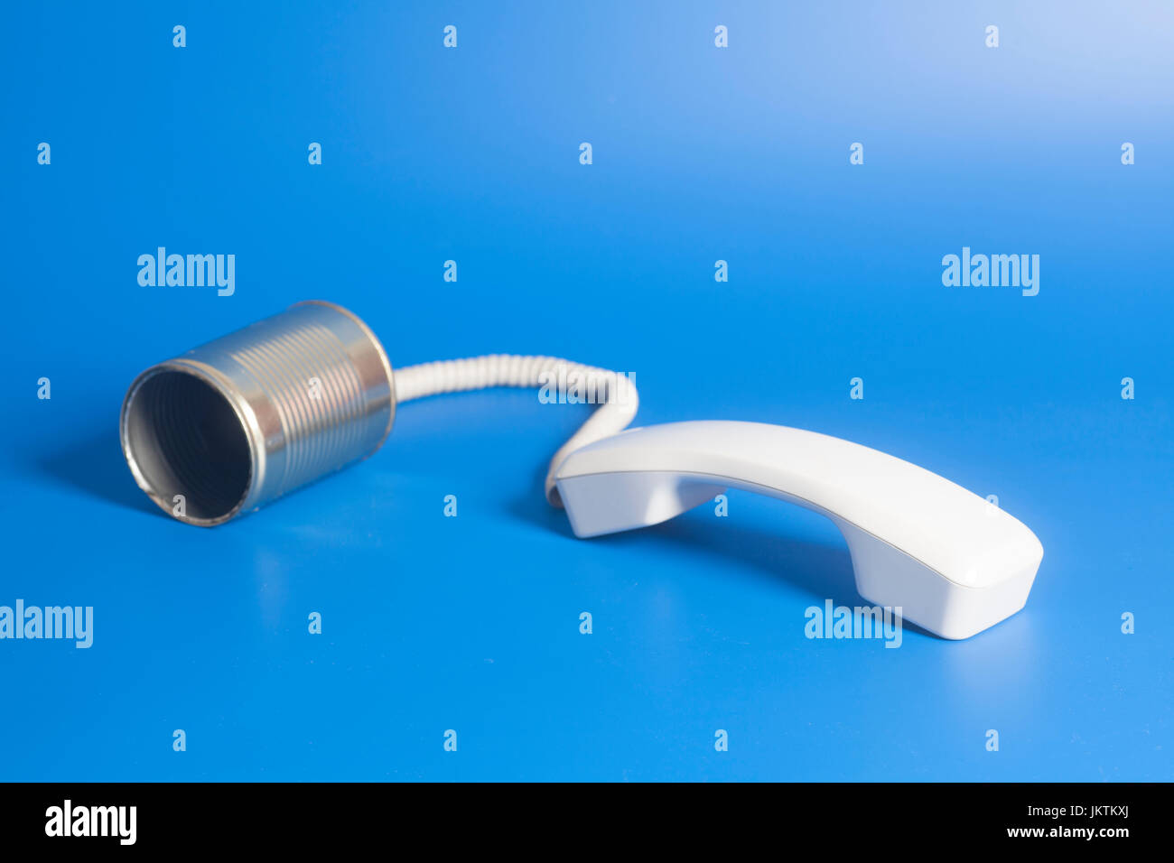 Tin can phone with handset on blue background Stock Photo - Alamy