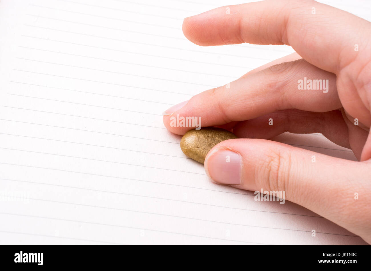 Little gold color pebble in the hand Stock Photo - Alamy